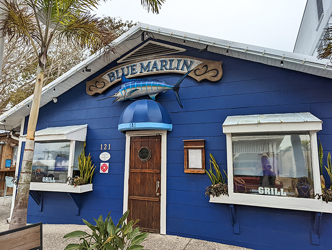 The vibrant blue exterior of Blue Marlin beckons seafood lovers with its charming cottage style and iconic marlin signage.