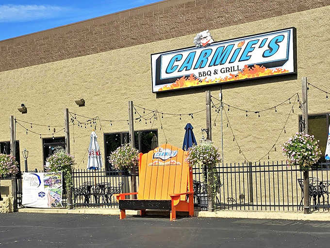 The inviting façade of Carmie's BBQ & Grill, where that bright orange chair practically screams "come sit a spell" to hungry passersby.