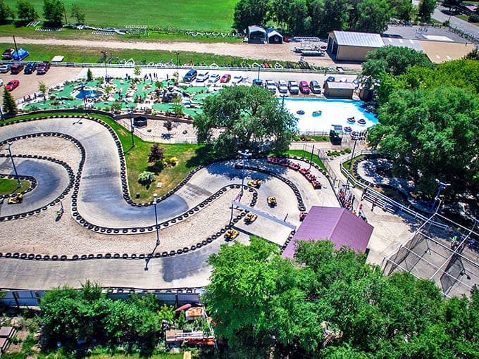 An aerial view of Casey's Amusement Park reveals its perfect formula for family fun: winding go-kart tracks, mini-golf courses, and a sparkling bumper boat pool nestled among mature trees.