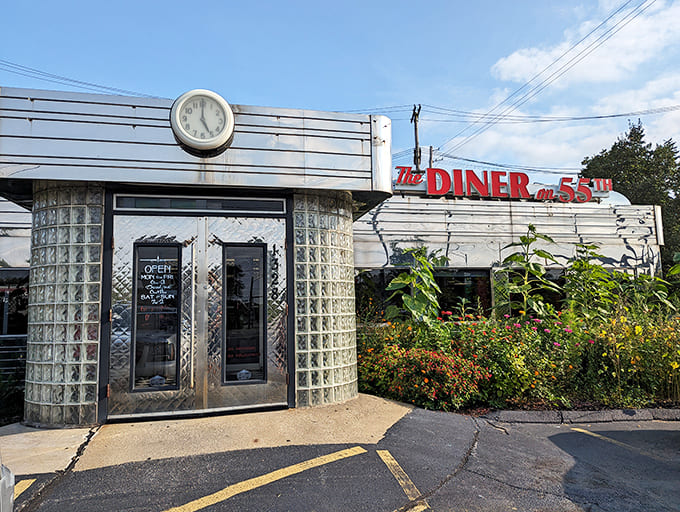 The gleaming stainless steel exterior of The Diner on 55th stands as a shining beacon of nostalgia, complete with vintage clock and glass block entrance.