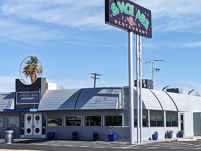 The iconic silver-domed exterior of Space Age Restaurant stands like a retro spaceship landed in the Arizona desert, complete with vibrant blue planters.