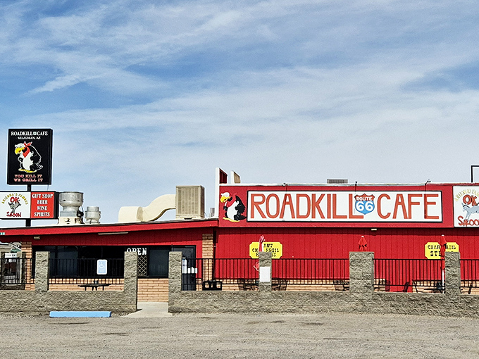 The iconic red exterior of Roadkill Cafe stands out against the Arizona sky, beckoning hungry travelers with its humorous "Route 66" signage and unmistakable character.