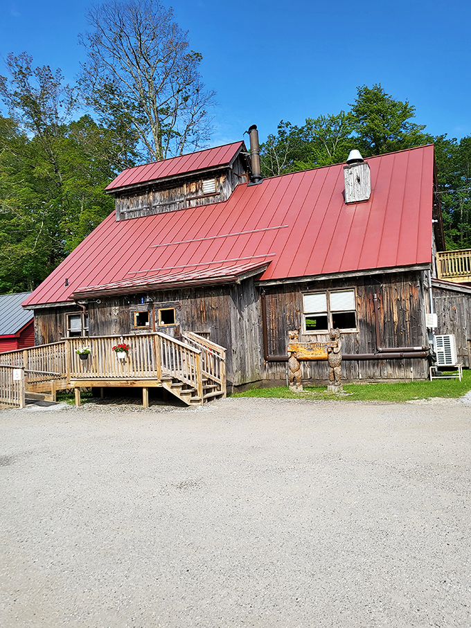 A weathered wooden sugar shack with a bright red roof stands ready to transform ordinary mornings into breakfast memories worth savoring.