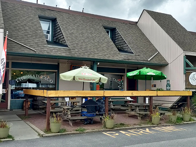 The Mad Taco's unassuming exterior hides a world of smoky delights, with picnic tables ready for hungry travelers seeking flavor nirvana.