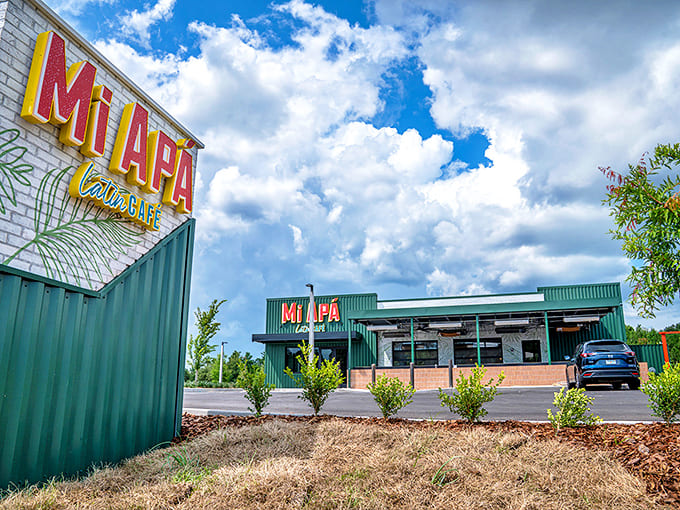 The vibrant green exterior of Mi Ap&aacute; Latin Caf&eacute; stands like a tropical oasis against the Florida sky, promising authentic flavors within.