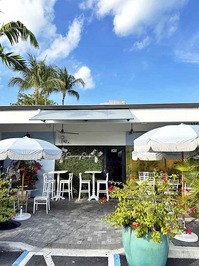 Sunny Side Caf&eacute; & Eatery welcomes guests with fringe-trimmed umbrellas and turquoise planters, creating a tropical oasis that promises culinary delights beyond the ordinary.