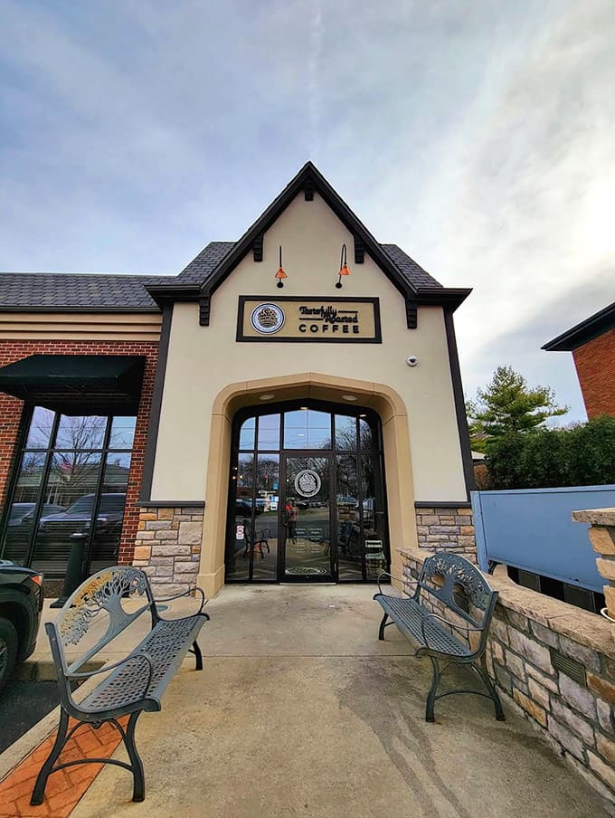 The charming Tudor-style exterior of Tastefully Roasted Coffee welcomes visitors with its peaked roof and cozy benches &ndash; a hint of the warmth waiting inside.