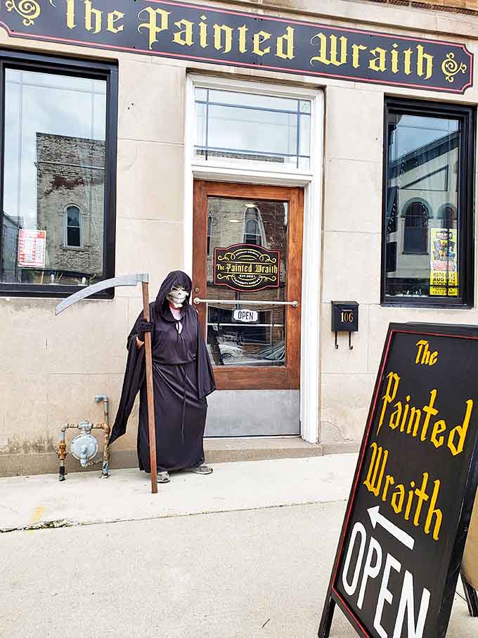 The Painted Wraith's storefront beckons with gothic charm, complete with a grim reaper greeter who's clearly taking the "customer service" role to the afterlife.