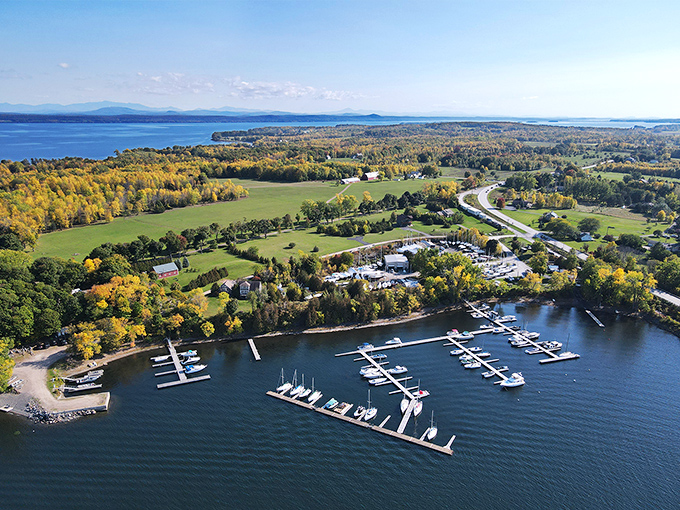 Aerial view of Grand Isle's marina, where boats bob gently in Lake Champlain's crystal waters beneath Vermont's endless sky.