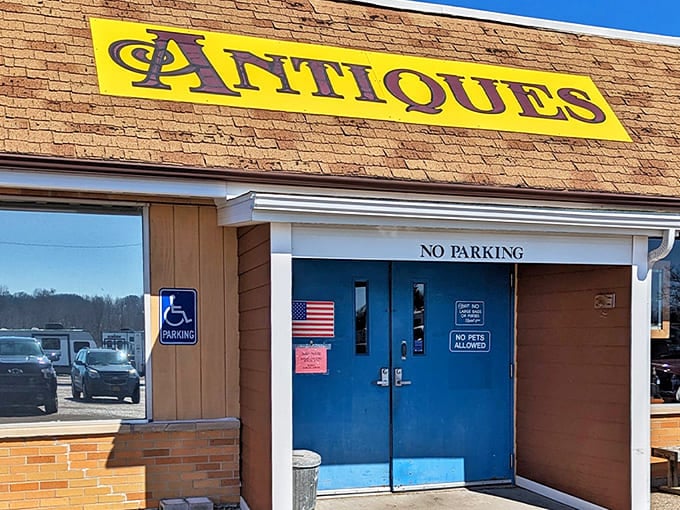 The iconic yellow "ANTIQUES" sign beckons treasure hunters like a lighthouse for nostalgia seekers in Coloma, Michigan.