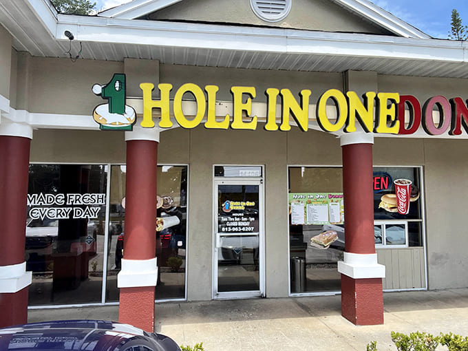 The cheerful yellow signage of Hole in One Donuts promises sweet salvation for early risers and breakfast enthusiasts alike.
