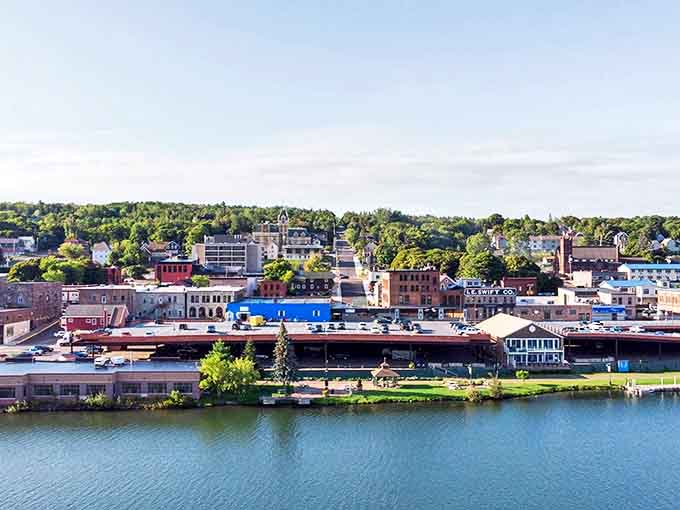 Houghton's waterfront panorama showcases the perfect marriage of nature and small-town charm, with historic buildings nestled against verdant hillsides.