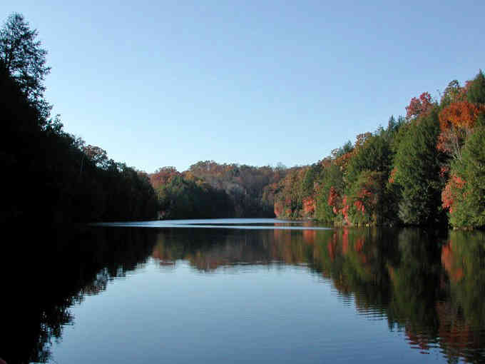 Mirror-like waters of Lake Katharine reflect autumn's fiery palette, creating nature's perfect symmetry. Ohio's hidden gem at its most photogenic moment.