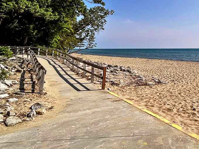 A wooden boardwalk hugs the shoreline, inviting visitors to stroll between lush greenery and golden sands at Lakeport State Park.
