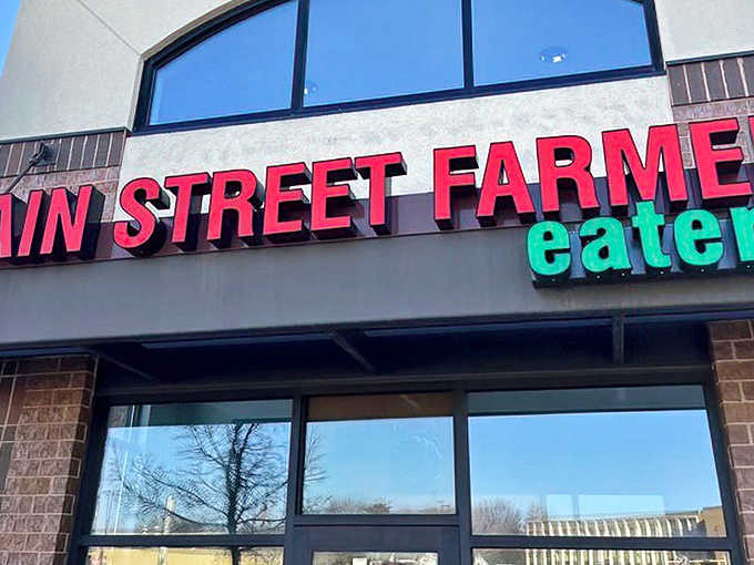 The bold red signage of Main Street Farmer Eatery promises farm-fresh delights within these brick walls &ndash; a beacon for hungry travelers.
