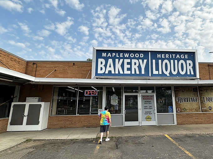 The iconic blue and white sign of Maplewood Bakery stands proudly against Minnesota skies, promising sweet treasures and spirited companions within.
