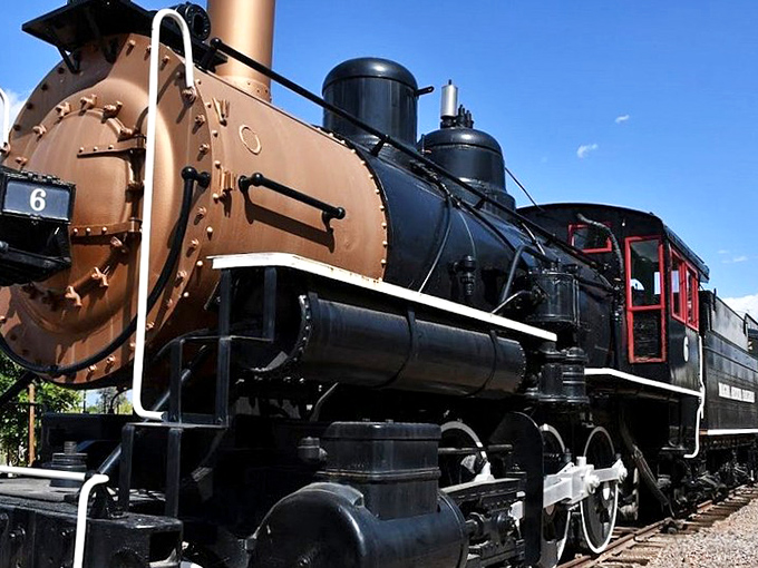 A majestic copper-colored steam locomotive stands proudly at McCormick-Stillman Railroad Park, its vintage charm capturing the golden age of rail travel.