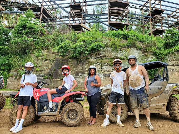 Mud-splattered adventurers pose proudly with their battle-worn Honda, looking like they've just conquered the wilderness one puddle at a time.