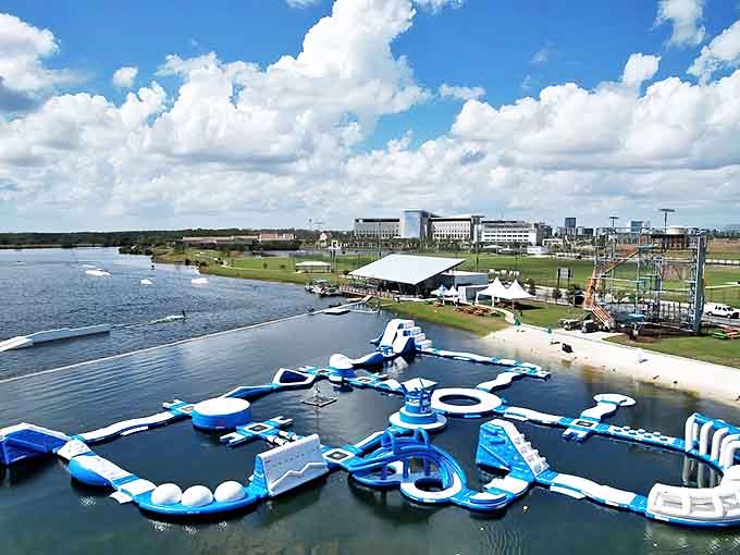 Nona Adventure Park's blue and white inflatable playground creates a striking contrast against the sparkling Orlando waters, beckoning adventure-seekers of all ages.