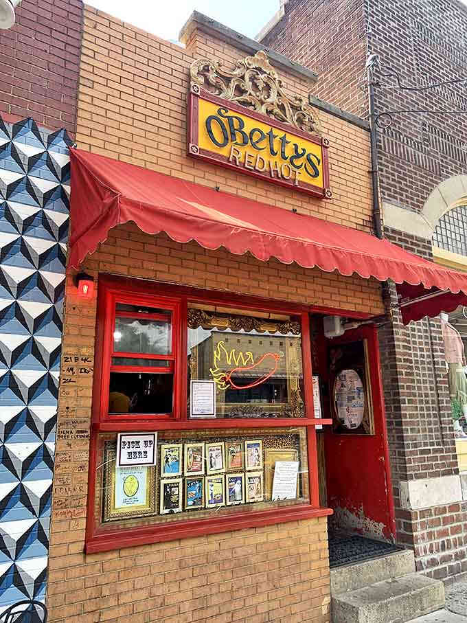 The iconic brick facade of O'Betty's Red Hot beckons with its vibrant red awning and ornate gold signage &ndash; a theatrical prelude to the culinary performance waiting inside.