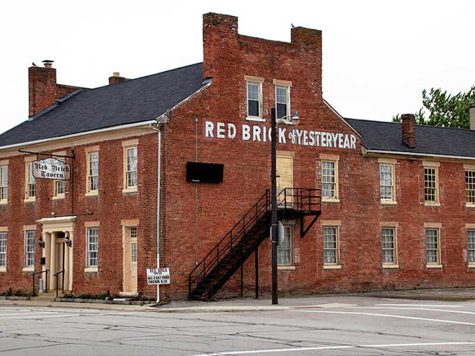 The historic Red Brick Tavern stands proudly in London, Ohio, its weathered facade telling stories of centuries past while promising delicious adventures within.