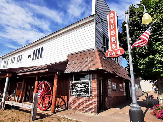 The iconic red neon sign of Stubbs Bar glows against the twilight sky, beckoning curious travelers with promises of cold beer and countless curiosities.
