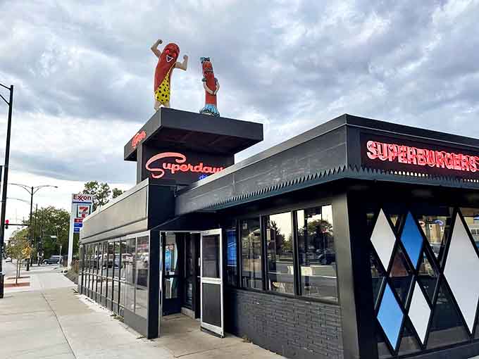 Superdawg's iconic exterior stands proud with its cartoon hot dog mascots waving from the roof, a beacon of deliciousness on Chicago's Northwest Side.