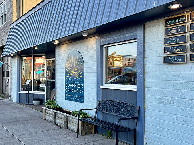 Superior Creamery's charming blue-trimmed facade welcomes visitors with its sunshine-ray logo, promising sweet treats but hiding savory secrets within.