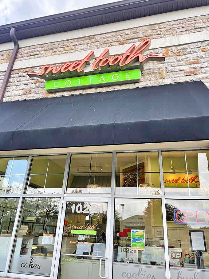 Sweet Tooth Cottage's welcoming storefront promises sugary adventures with its vibrant sign &ndash; like finding the entrance to a delicious secret society.