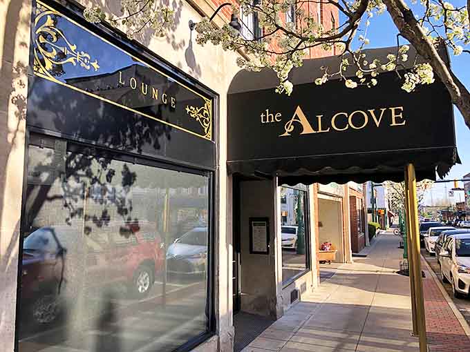 The elegant black awning of The Alcove beckons from South Main Street, promising culinary magic within Mount Vernon's dining crown jewel.