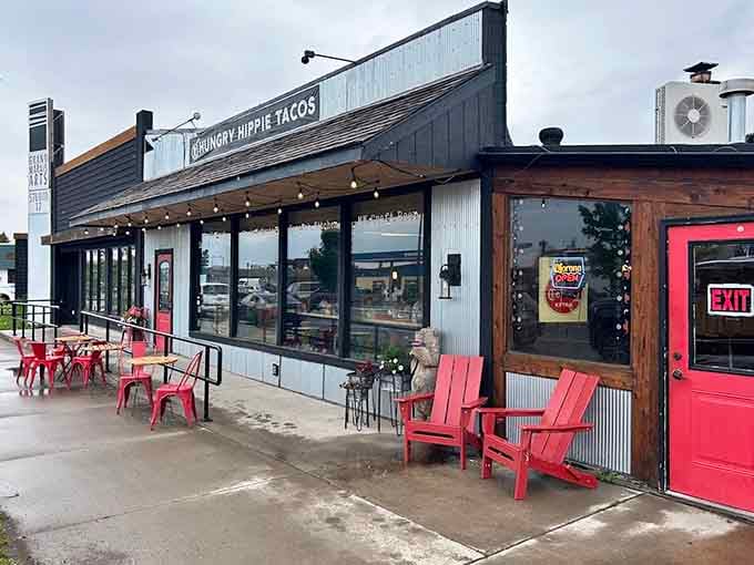 The cheerful exterior welcomes hungry travelers with red Adirondack chairs and string lights that promise good times ahead.