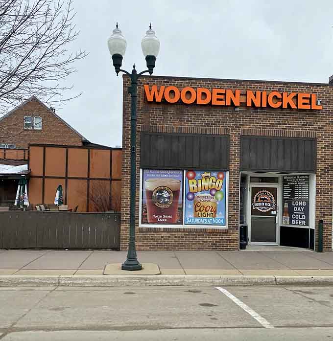 That bright orange "Wooden Nickel" sign beckons like a beacon of deliciousness on Marshall's Main Street, promising comfort food adventures within.