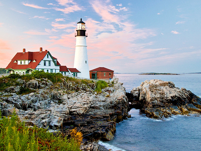 Portland Head Light stands majestically against a pastel sky, its white tower and keeper's house creating the quintessential Maine postcard moment.
