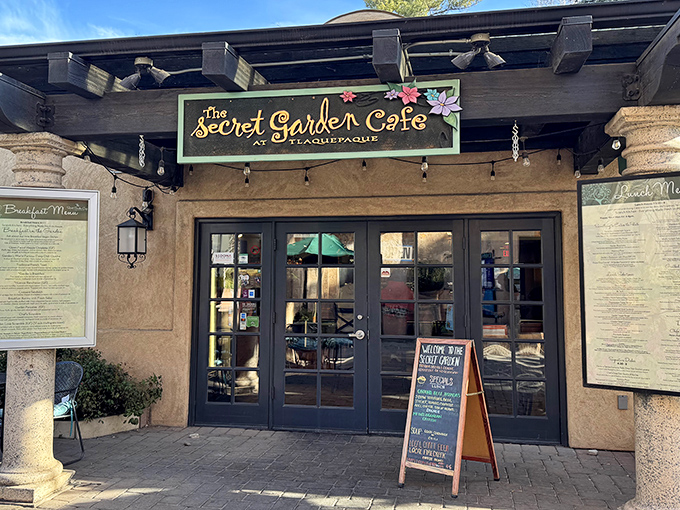 The welcoming facade of Secret Garden Caf&eacute; beckons with its charming sign and warm adobe exterior&mdash;a prelude to the culinary magic within.