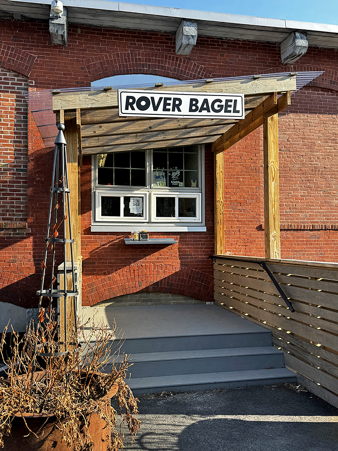 The unassuming entrance to Rover Bagel beckons with rustic charm &ndash; that wooden sign promising wood-fired wonders within those brick walls.