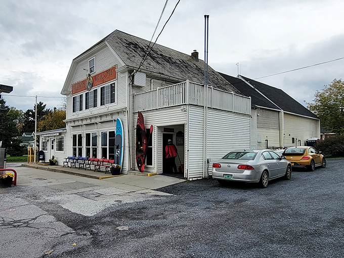 The classic white clapboard exterior of Hero's Welcome stands proudly against Vermont skies, promising treasures both edible and practical within its historic walls.