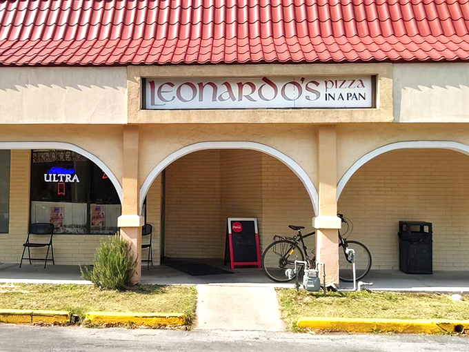Leonardo's iconic storefront beckons with its distinctive red roof and arched entryway – a portal to pizza paradise that's been tempting Gainesville residents for decades.