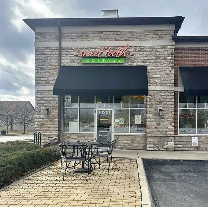 Sweet Tooth Cottage welcomes visitors with its charming stone facade and cheerful signage, promising sweet adventures inside.