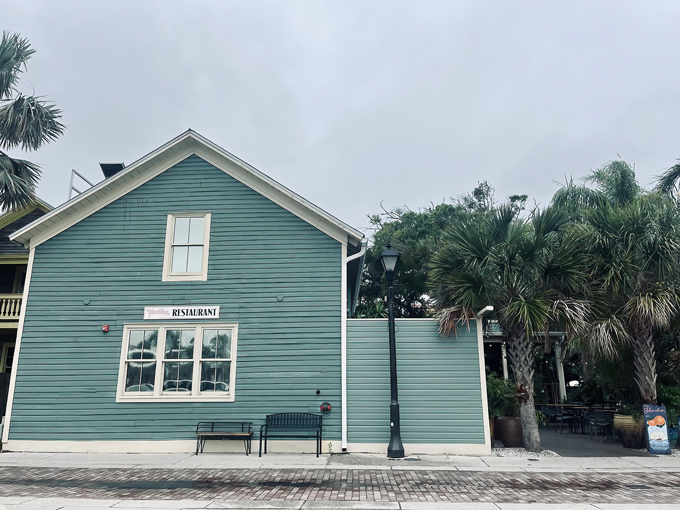 The seafoam-green cottage exterior of The Floridian whispers rather than shouts, standing between palm trees like a delicious secret waiting to be discovered.