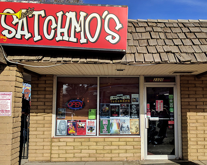 The unassuming brick exterior of Satchmo's, with its vibrant red sign, promises authentic flavors that belie its modest appearance.