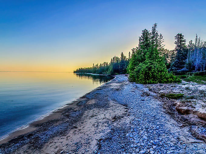 Sunset paints Thompson's Harbor State Park in golden hues, where Lake Huron meets pristine shoreline in a display that outshines any five-star resort view.