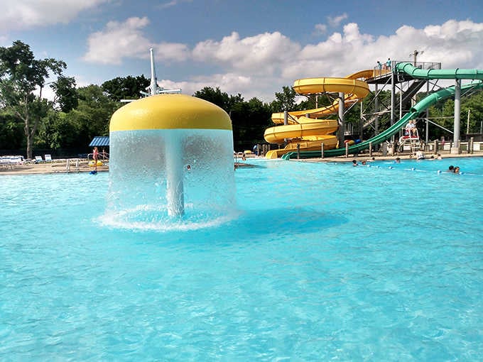 The iconic yellow mushroom fountain at Uhrichsville Water Park creates a refreshing centerpiece where kids squeal with delight as water cascades down.