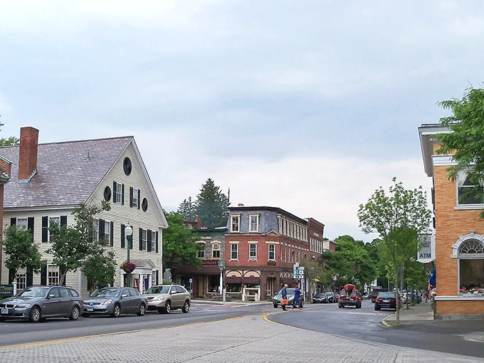Woodstock's main street welcomes visitors with classic New England charm &ndash; brick buildings, white trim, and mountains framing the perfect small-town scene.