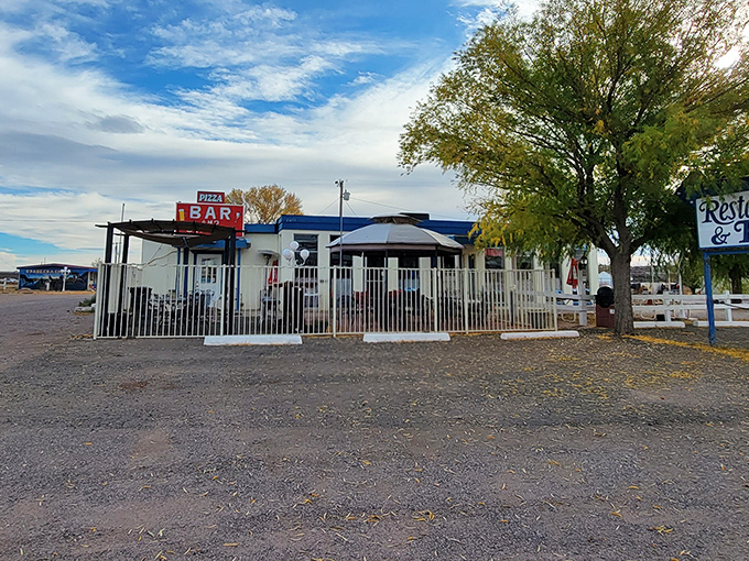A modest roadside oasis with "PIZZA" and "BAR" signs beckoning hungry travelers to discover what might be Arizona's most unexpected culinary treasure.