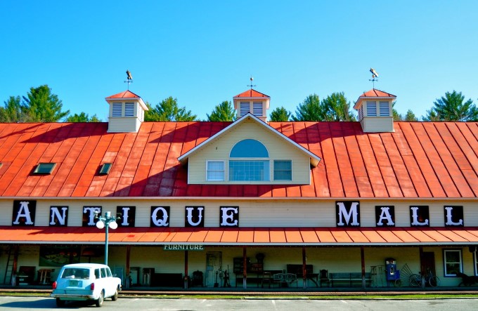 The iconic red roof and bold "ANTIQUE MALL" lettering promise treasure hunters a journey through time at this Quechee landmark.