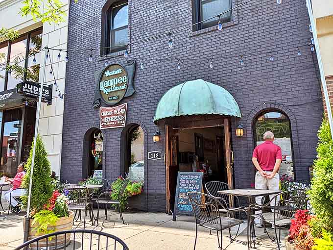 The iconic dark brick exterior of Kewpee beckons hungry visitors with its vintage charm and distinctive green awning &ndash; a Lansing landmark that's stood the test of time.