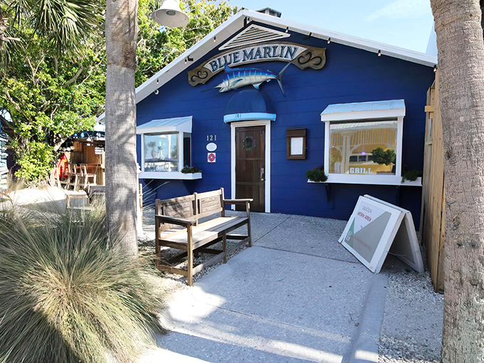 The vibrant blue exterior of Blue Marlin stands out like a sapphire against Anna Maria Island's landscape, beckoning seafood lovers with maritime charm.