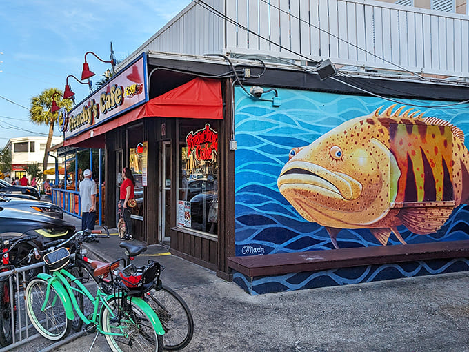 Frenchy's exterior beckons with its vibrant mural of a golden grouper swimming through azure waves &ndash; a colorful promise of the seafood treasures waiting inside.