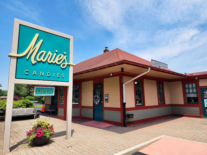 The iconic turquoise sign welcomes chocolate lovers to Marie's Candies, housed in a charming historic building that promises sweet adventures within.