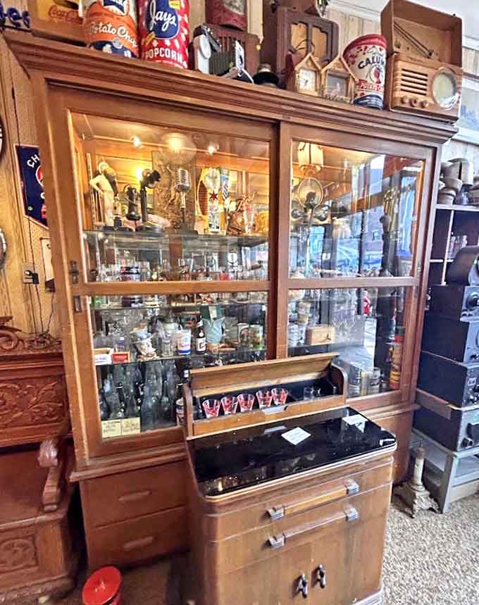 Glass cabinets showcase treasures within treasures, vintage bottles and collectibles arranged like museum exhibits.